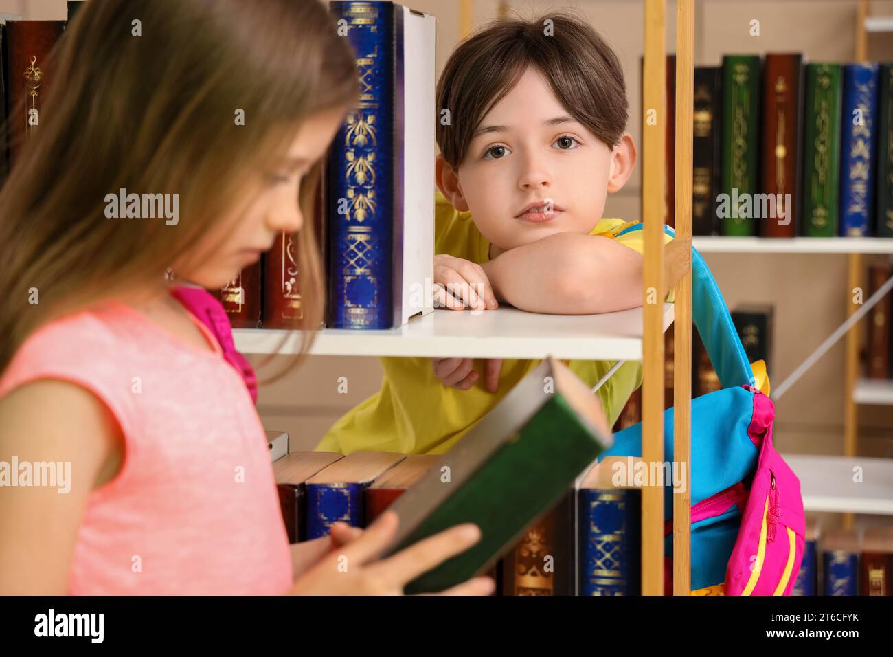 Cute little pupils in library Stock Photo - Alamy