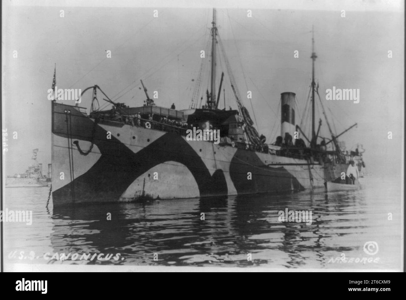 USS CANONICUS, three quarter length port view of camouflaged cargo ship ...