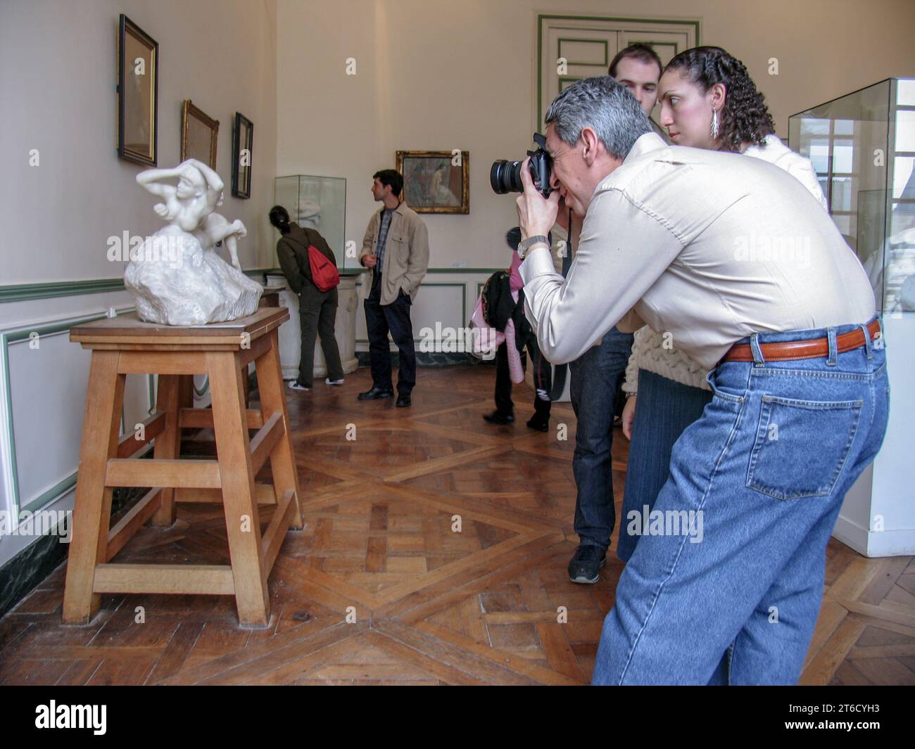 Tourist taking photos of sculpture in The Rodin Museum. The museum is ...