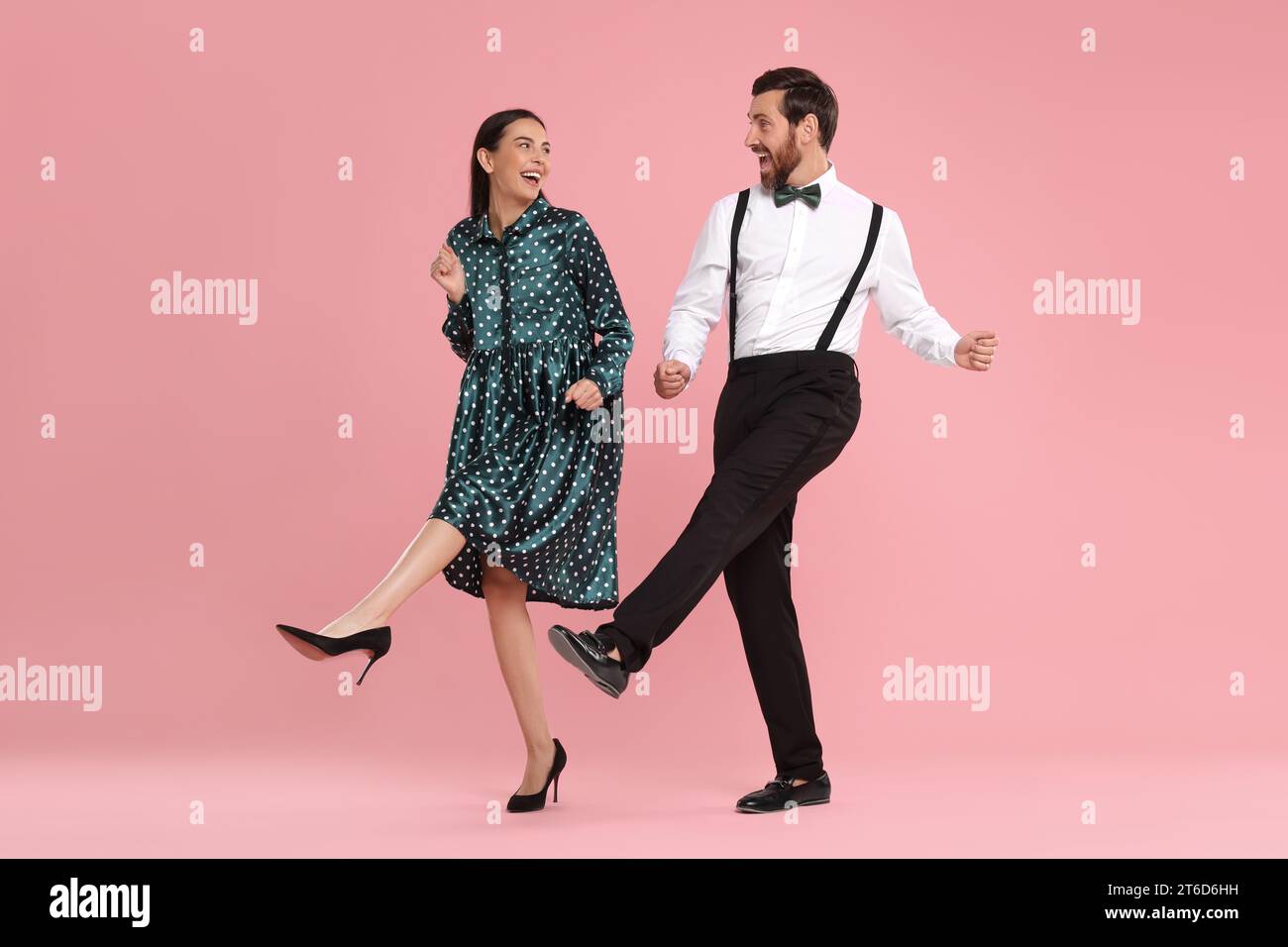 Happy couple dancing together on pink background Stock Photo - Alamy