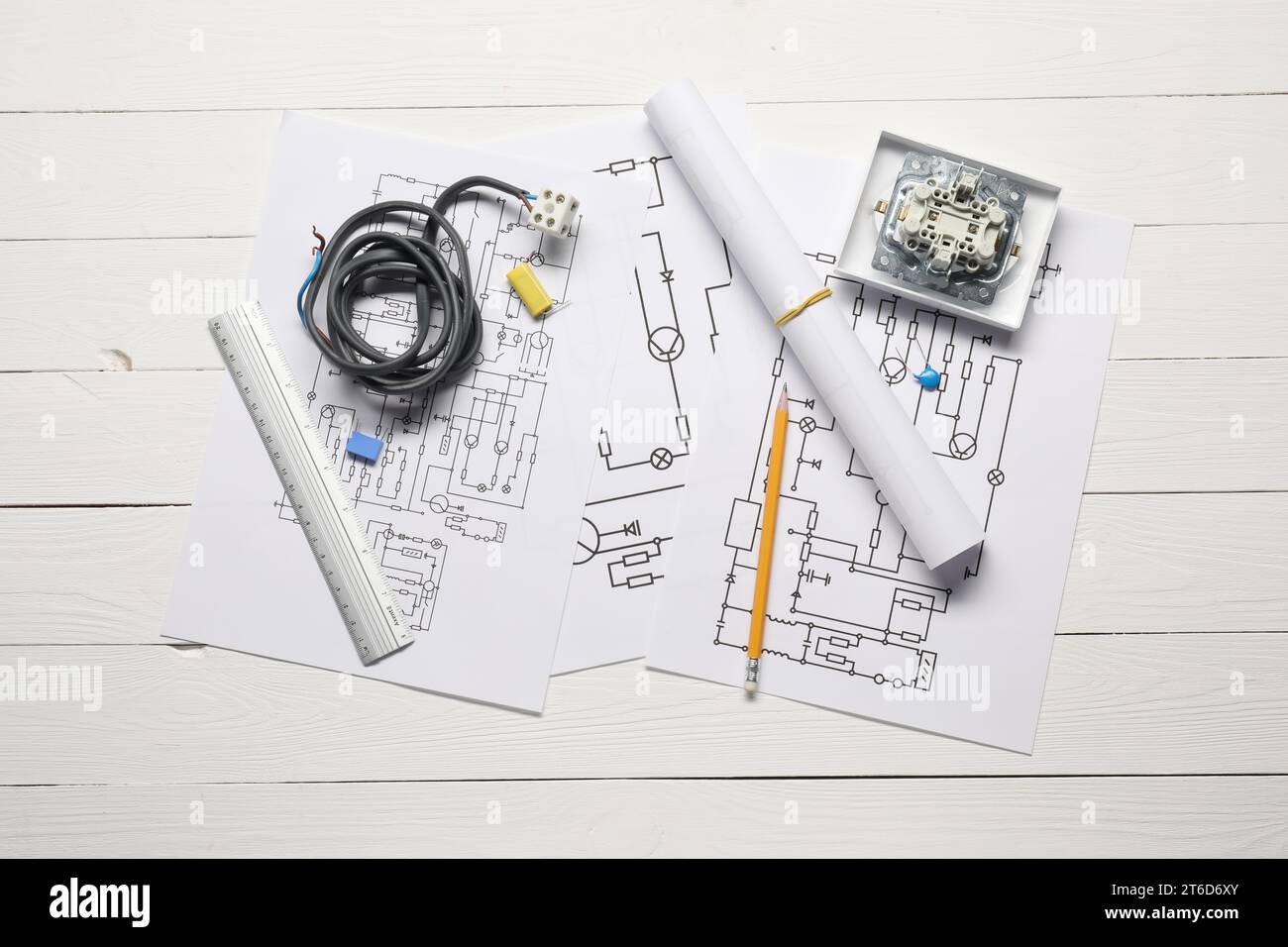 Wiring diagrams, wires and office stationery on white wooden table ...
