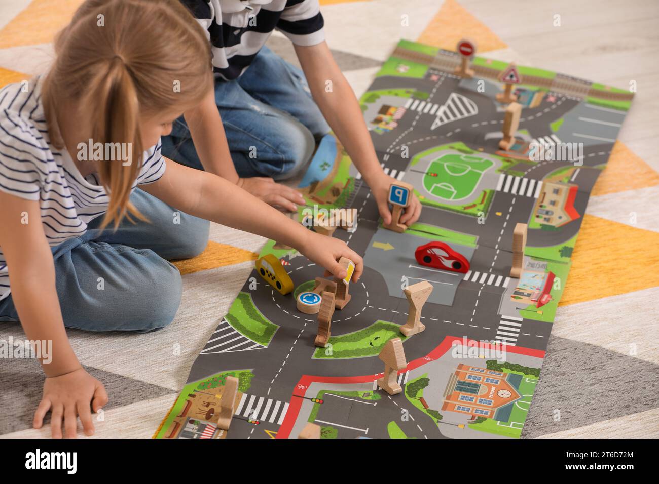Little children playing with set of wooden road signs and toy cars ...