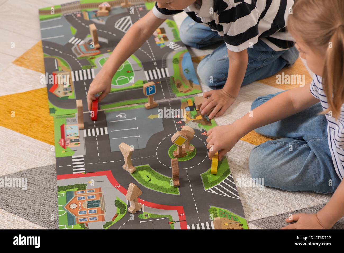 Little children playing with set of wooden road signs and toy cars ...