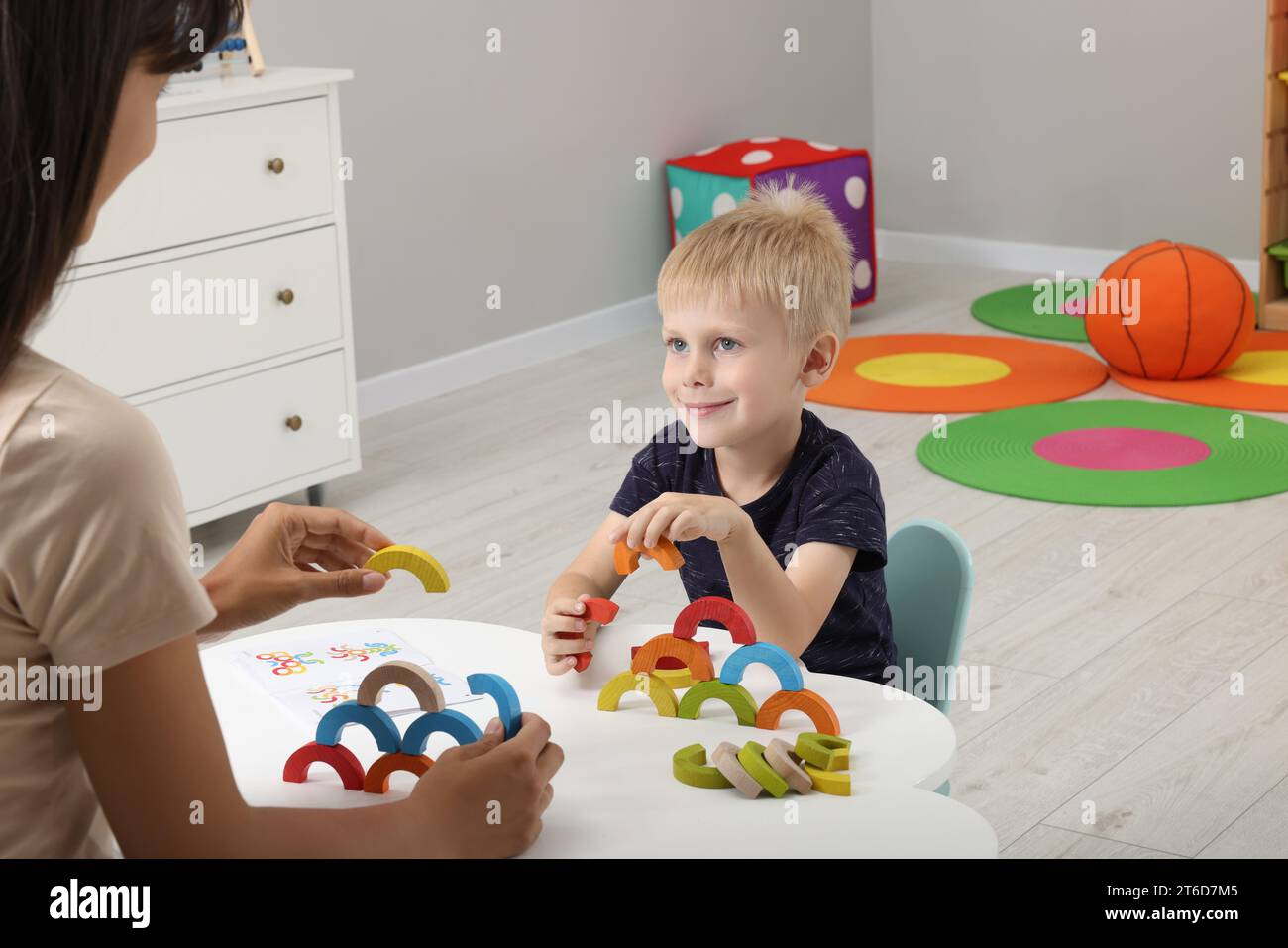Motor skills development. Mother helping her son to play with colorful ...