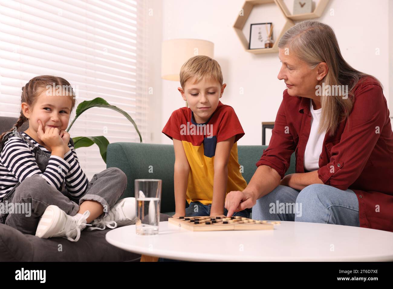 Family playing checkers at coffee table in room Stock Photo - Alamy