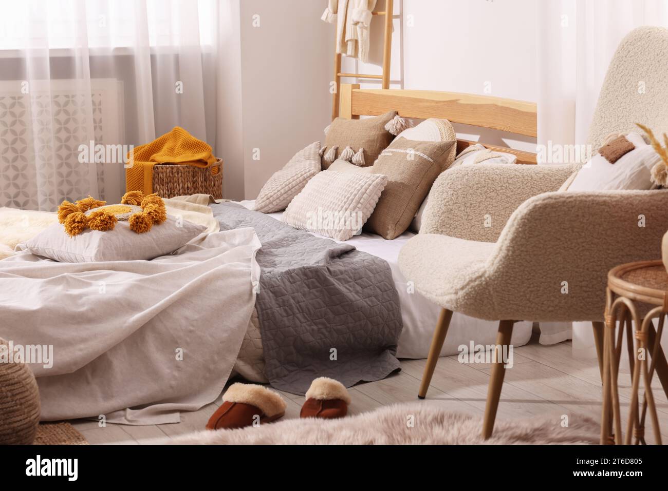 Large comfortable bed with soft pillows, blankets and slippers in room ...