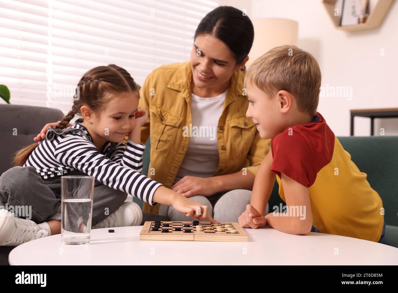 Family playing checkers at coffee table in room Stock Photo - Alamy