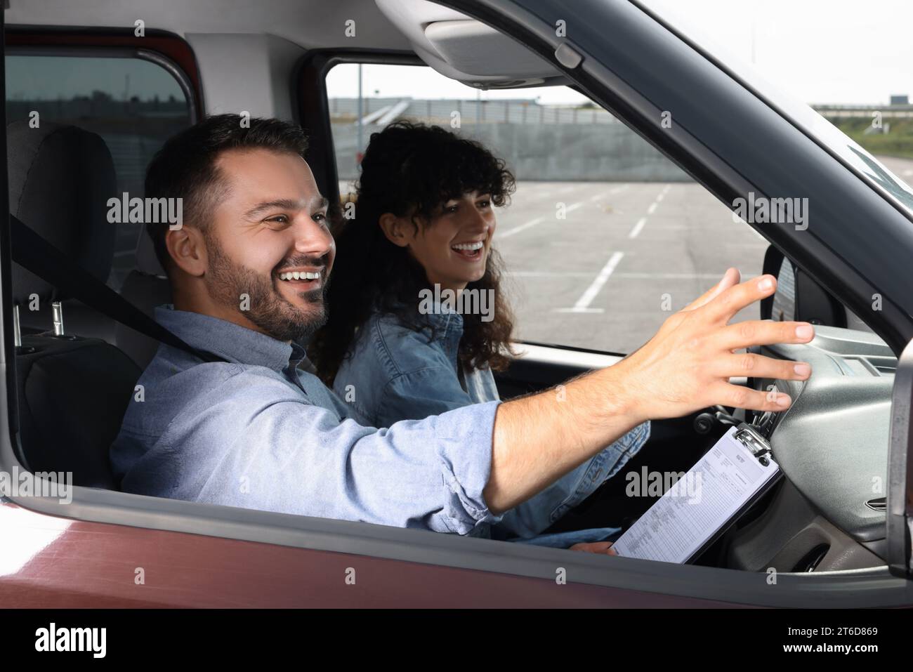 Driving school. Happy student passing driving test with examiner in car ...