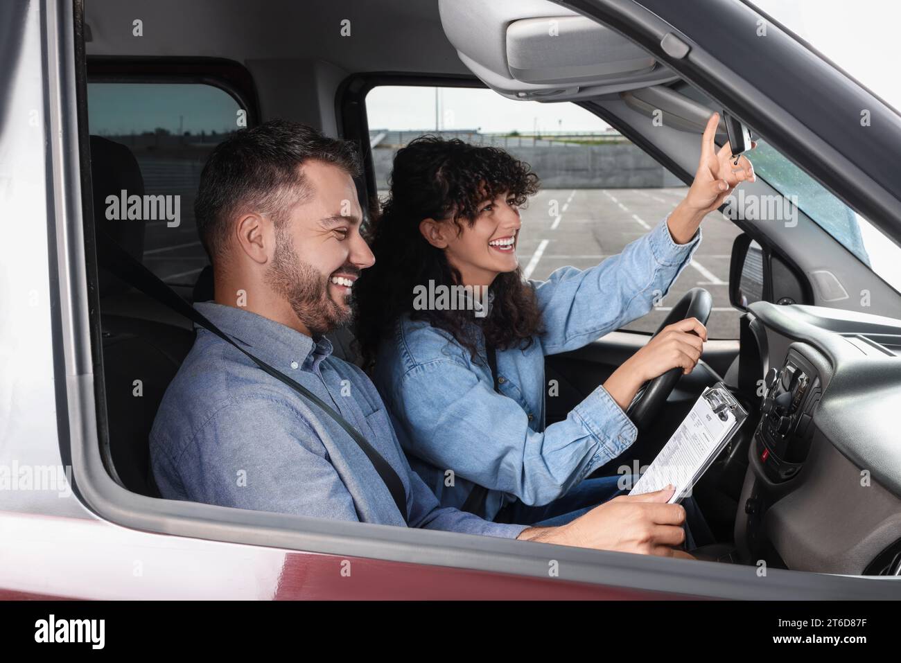 Driving school. Happy student passing driving test with examiner in car ...