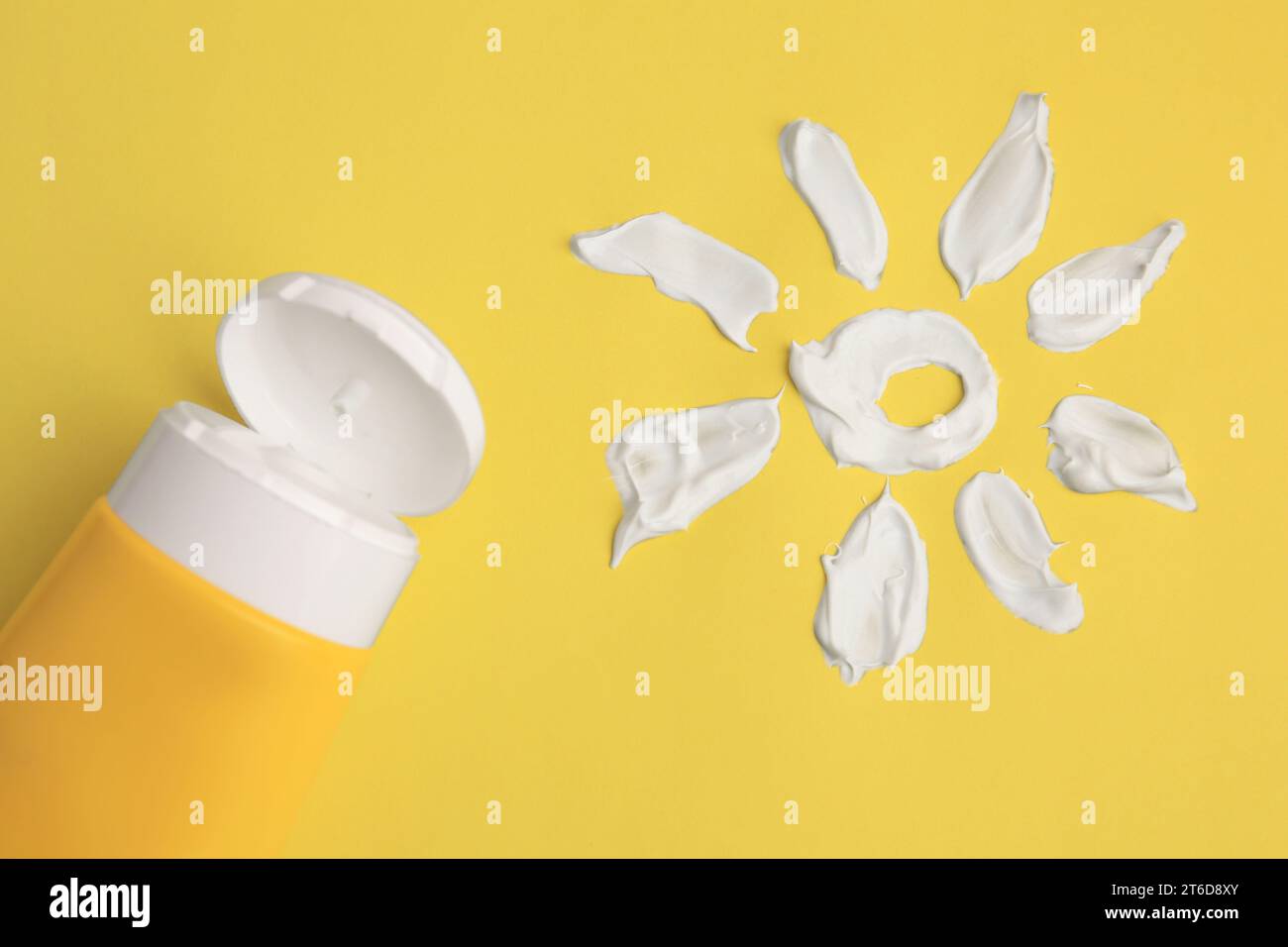 Drawing of sun and tube with sunscreen on yellow background, above view ...