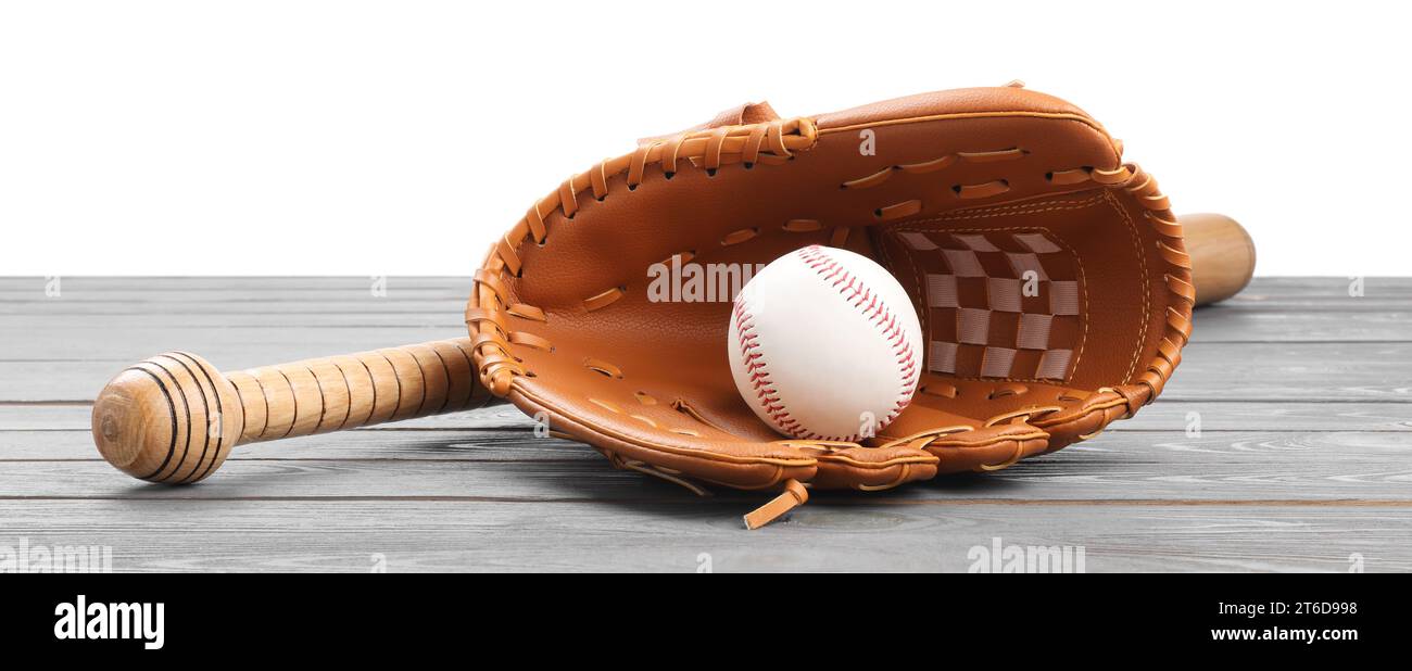 Baseball bat, ball and catcher's mitt on grey wooden table against ...