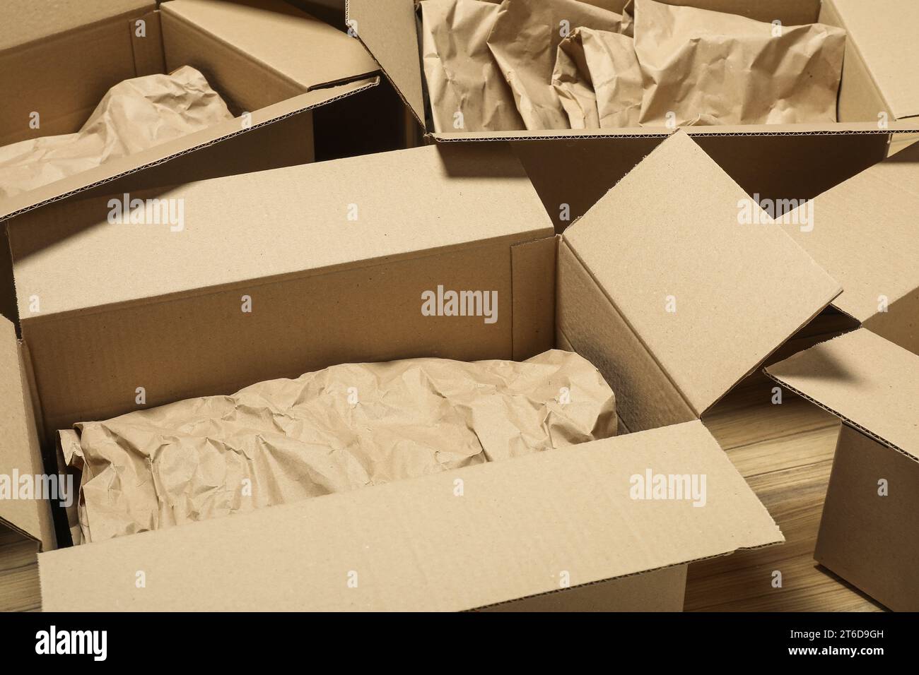 Many open cardboard boxes with crumpled paper on wooden floor Stock ...