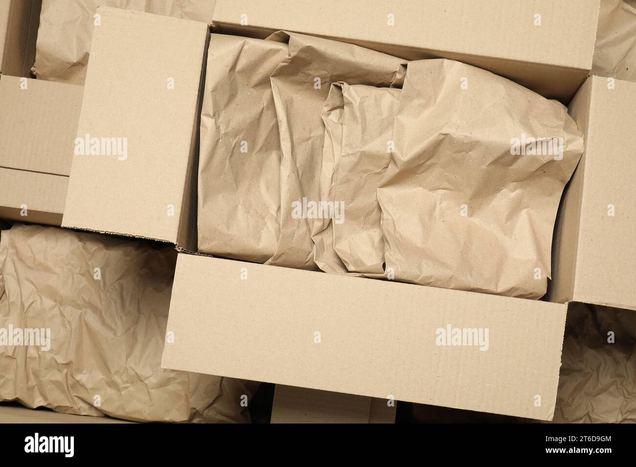 Many open cardboard boxes with crumpled paper as background, top view ...