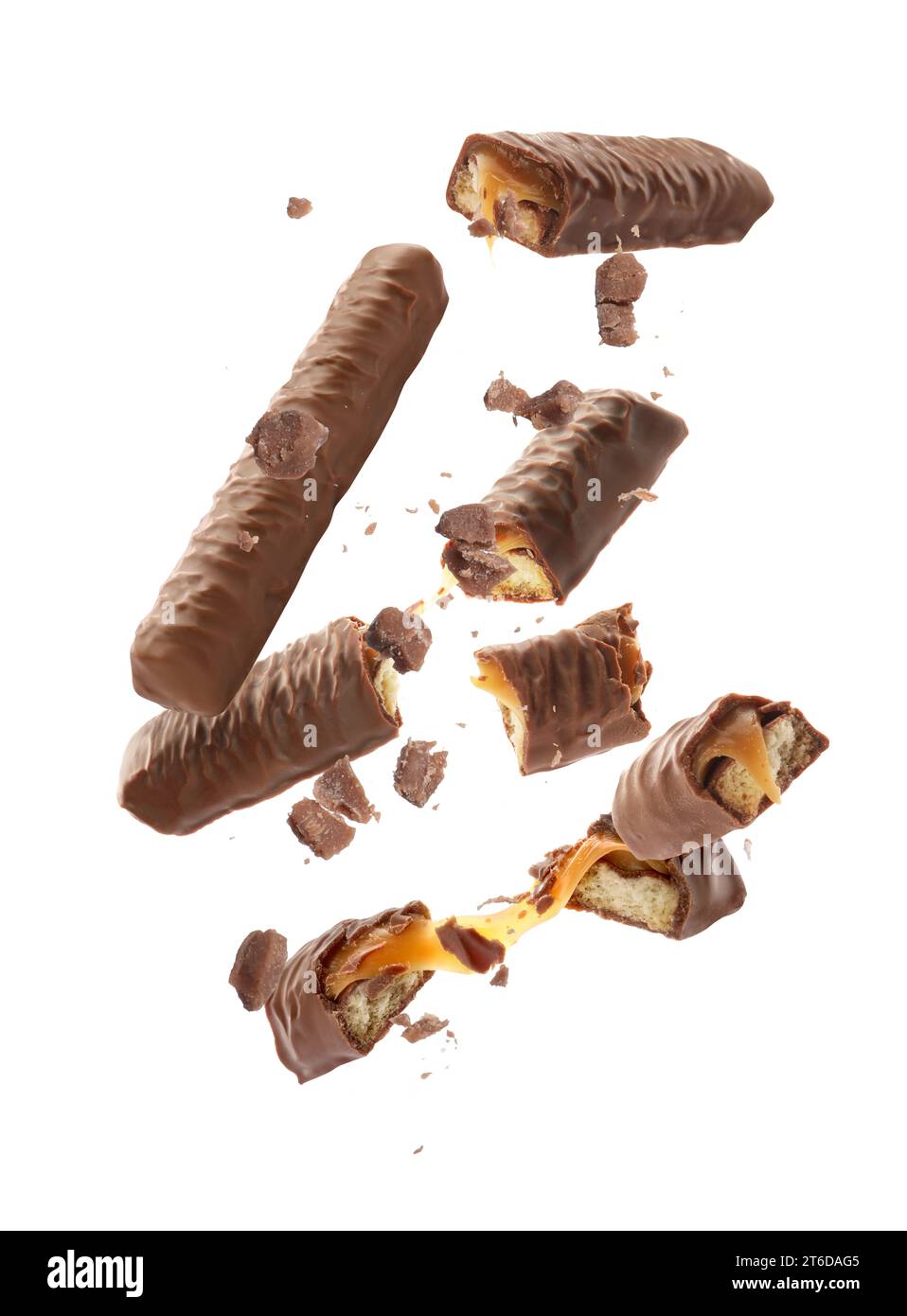 Whole and broken chocolate bars with caramel falling on white ...