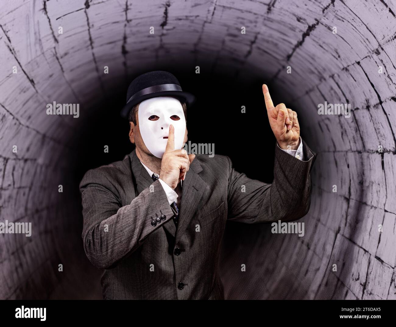 A man in a mask shows a gesture for silence before the enter of the ...