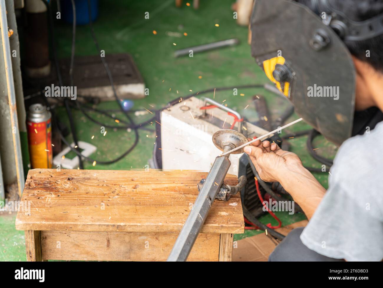 Technician welding and spark stainless foot adjustable in workshop ...