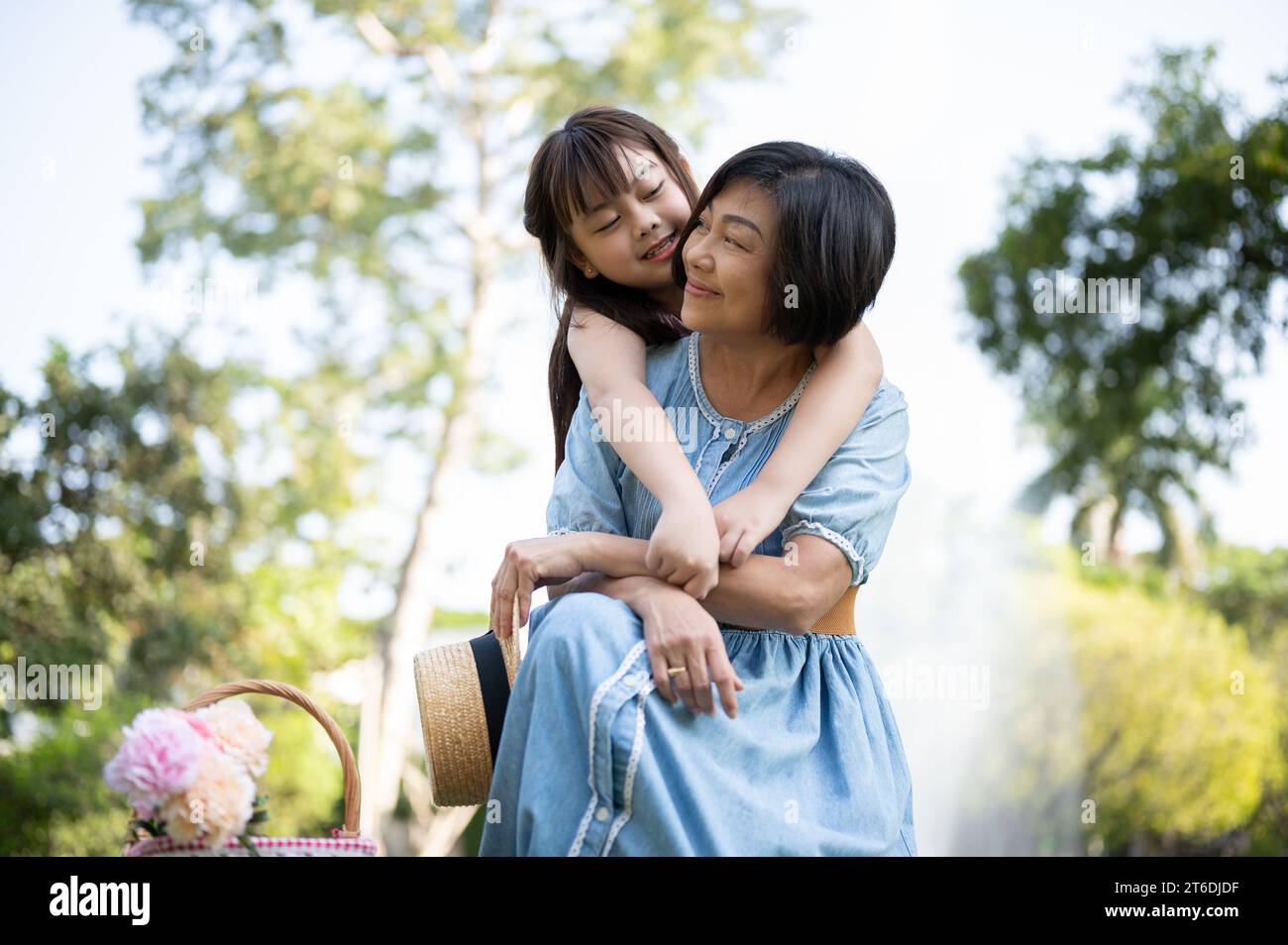 A happy senior Asian grandmother and her cute little girl granddaughter ...