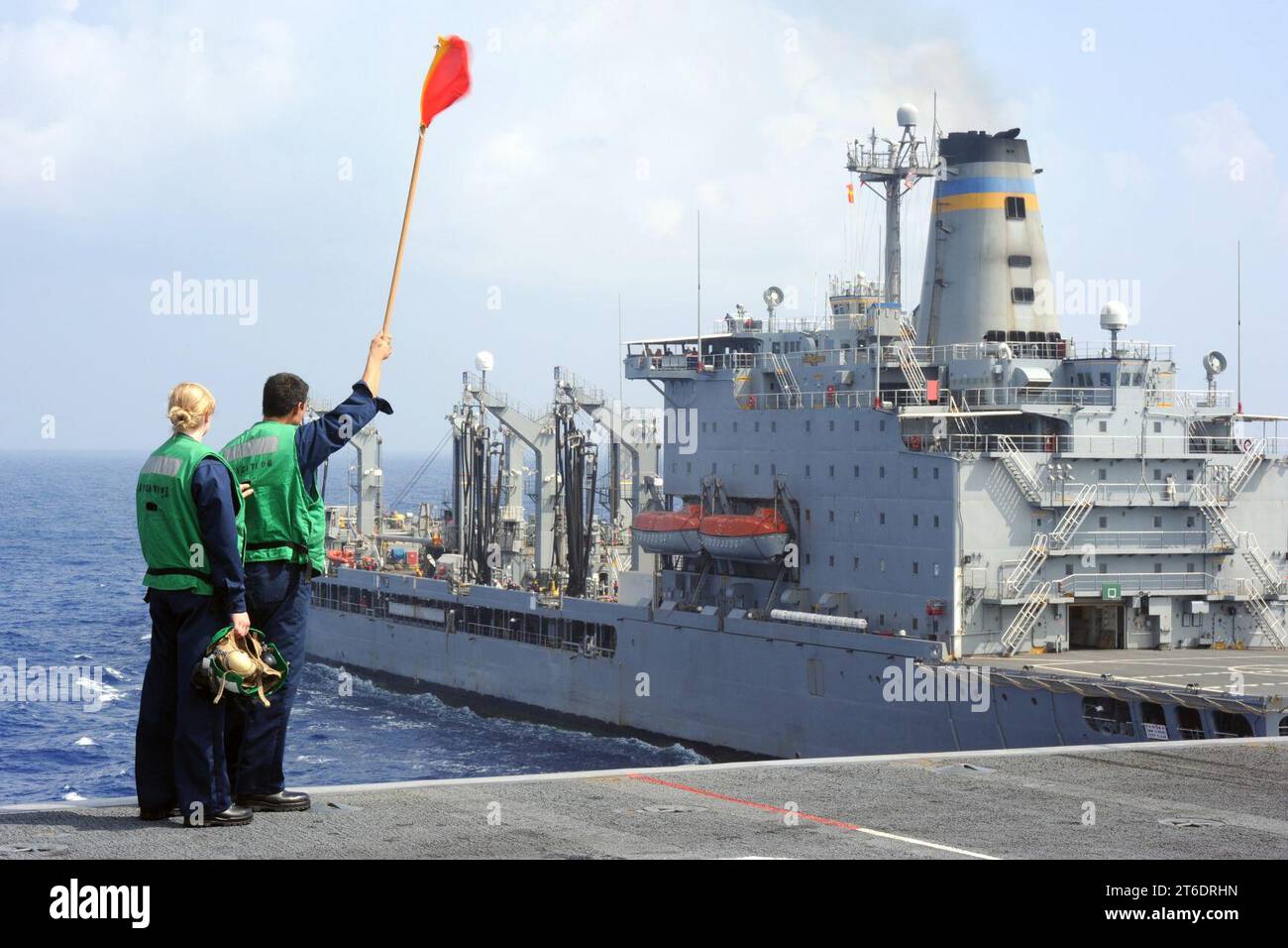 USS George Washington (CVN-73) sailors waving guide flag on flight deck ...