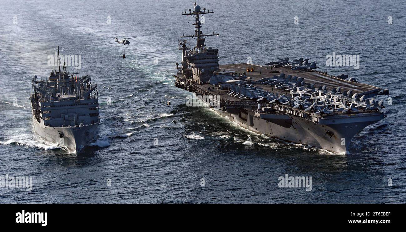 USS John C. Stennis and USNS Rainier conduct a vertical replenishment ...