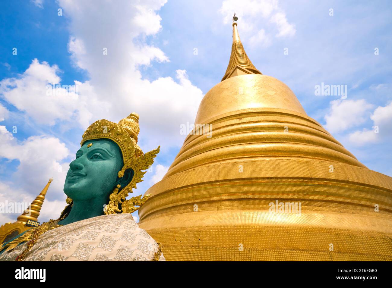 At the top, on the outside deck, a large, gold stupa with jade colored ...