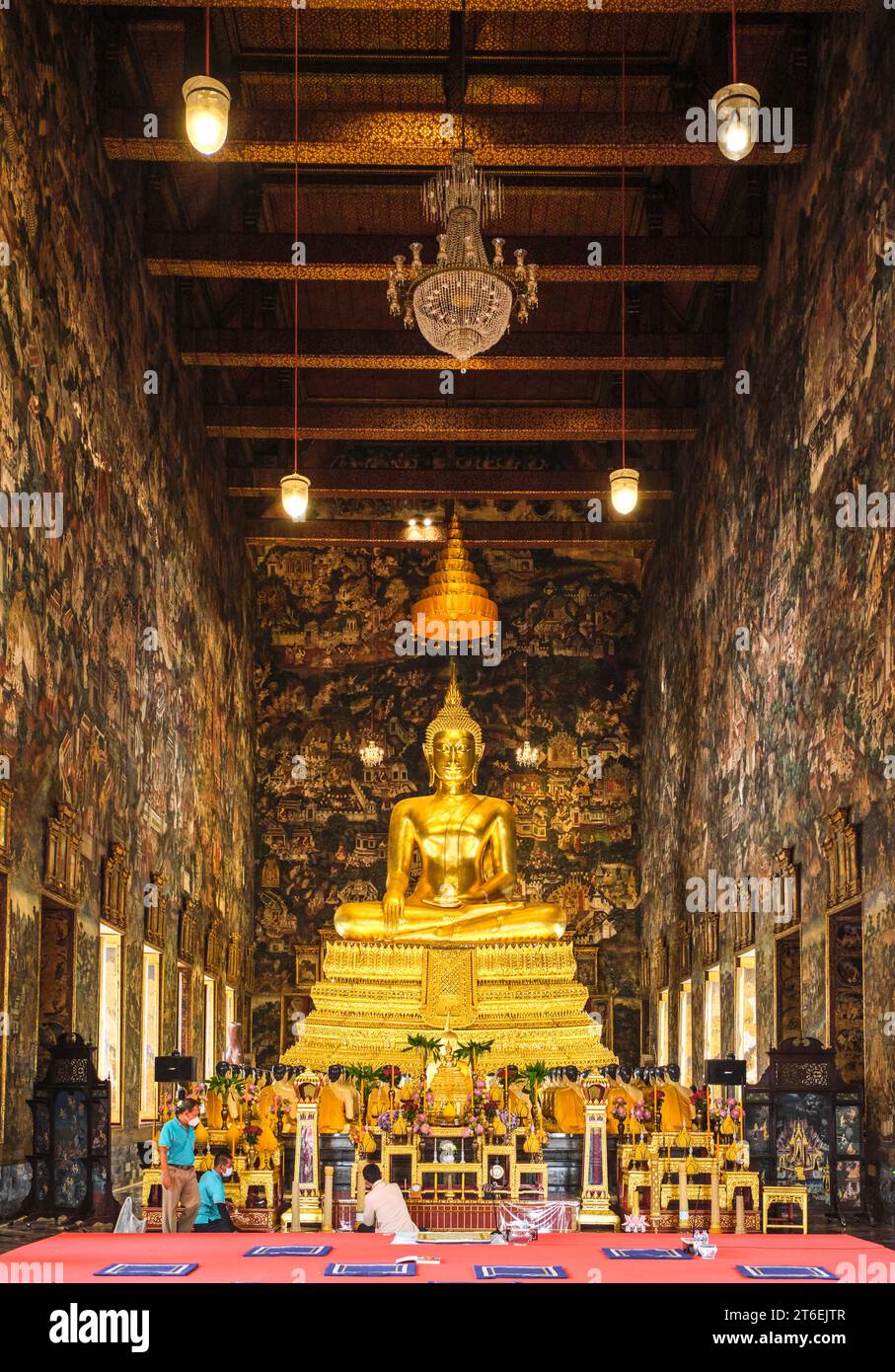 A large sitting, gold Buddha statue dominates the interior altar inside ...