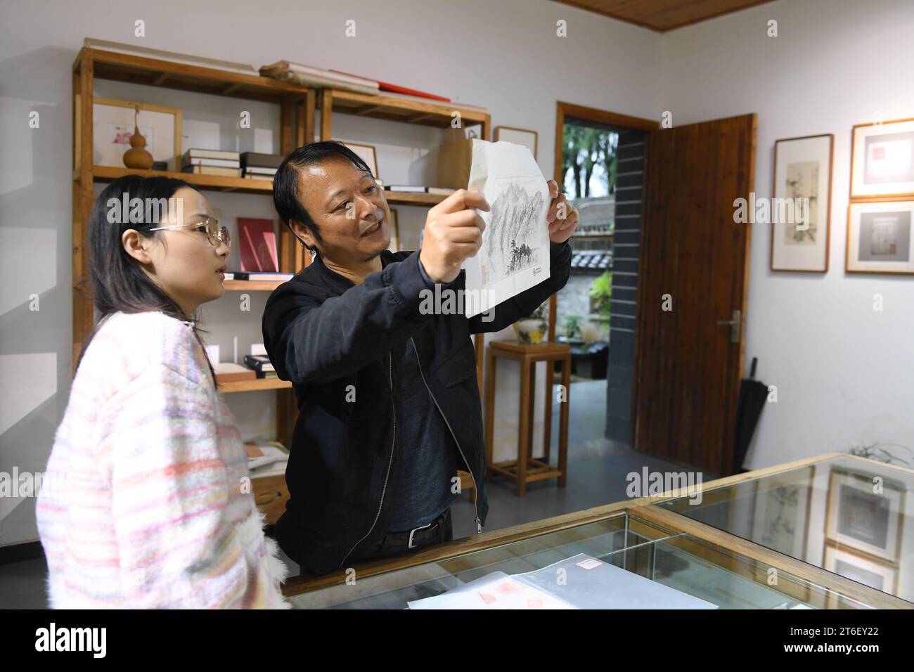(231110) -- QUZHOU, Nov. 10, 2023 (Xinhua) -- Huang Hongjian (R) shows ...