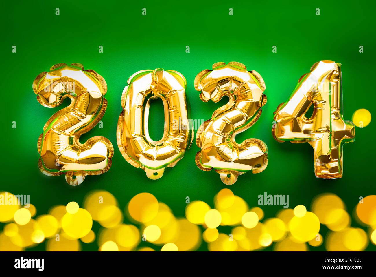 Happy New year 2024 celebration, Gold foil balloons number 2024 and festive bokeh lights on ...