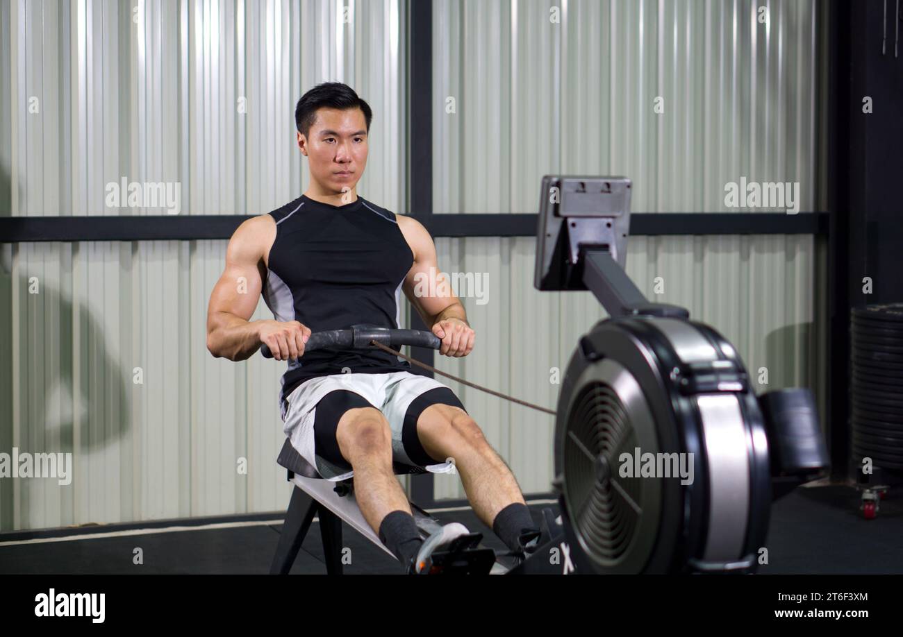 Fitness-conscious man passionately engaging in indoor rowing, in well ...