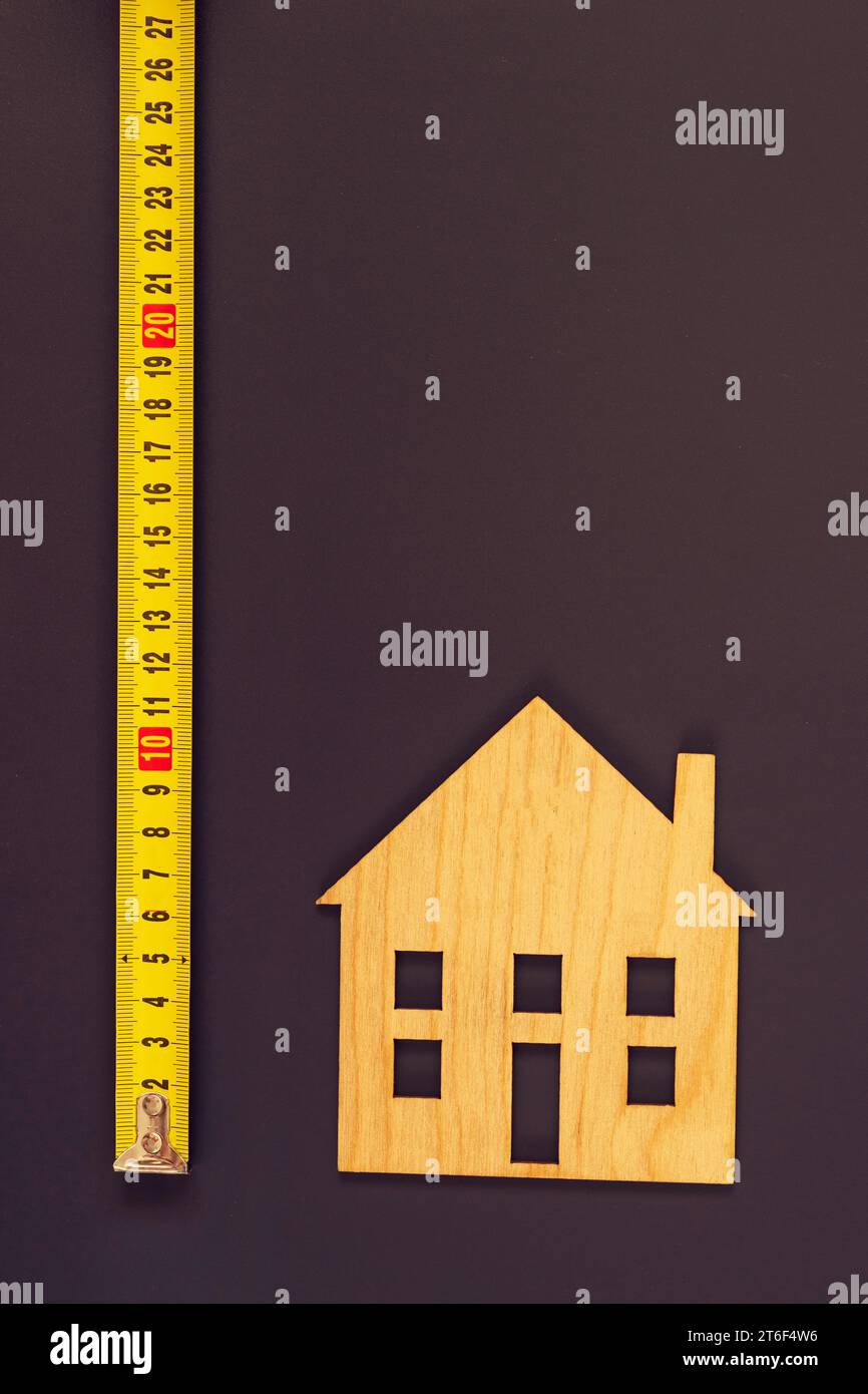 The image of the house on the background. Measurement of the size, tape ...