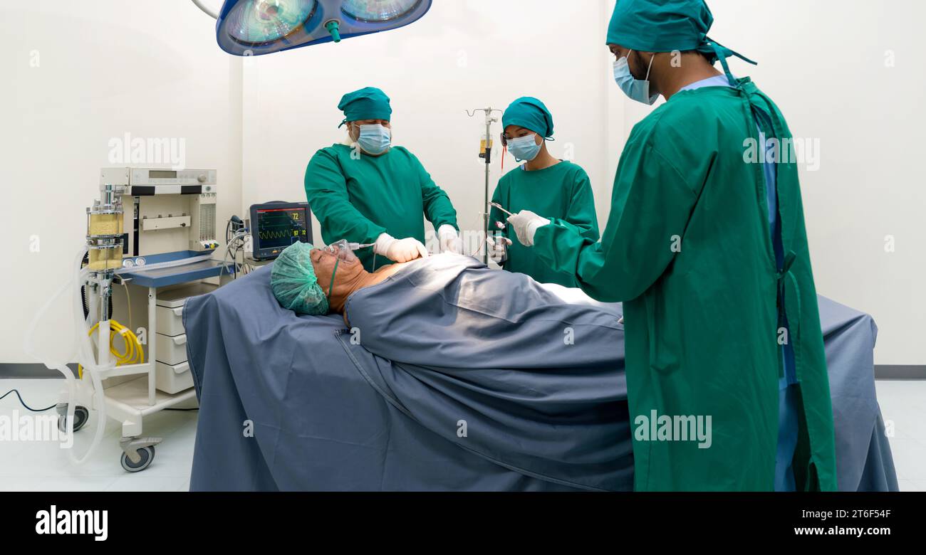 Group of surgeons, steeped in concentration, performing complex surgery ...