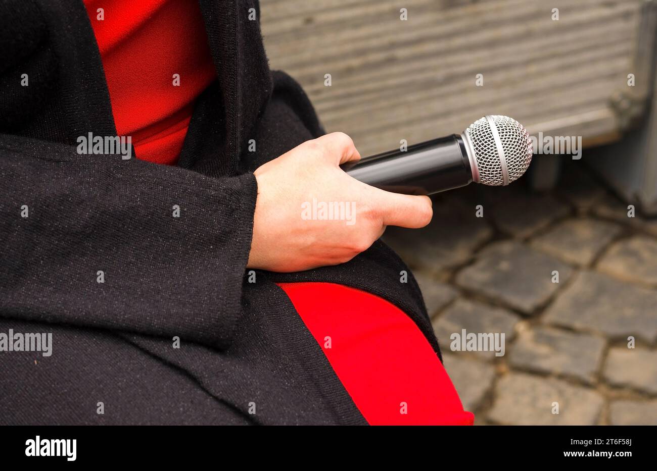 female hand holding microphone. Reporter interviewing outdoors. The ...