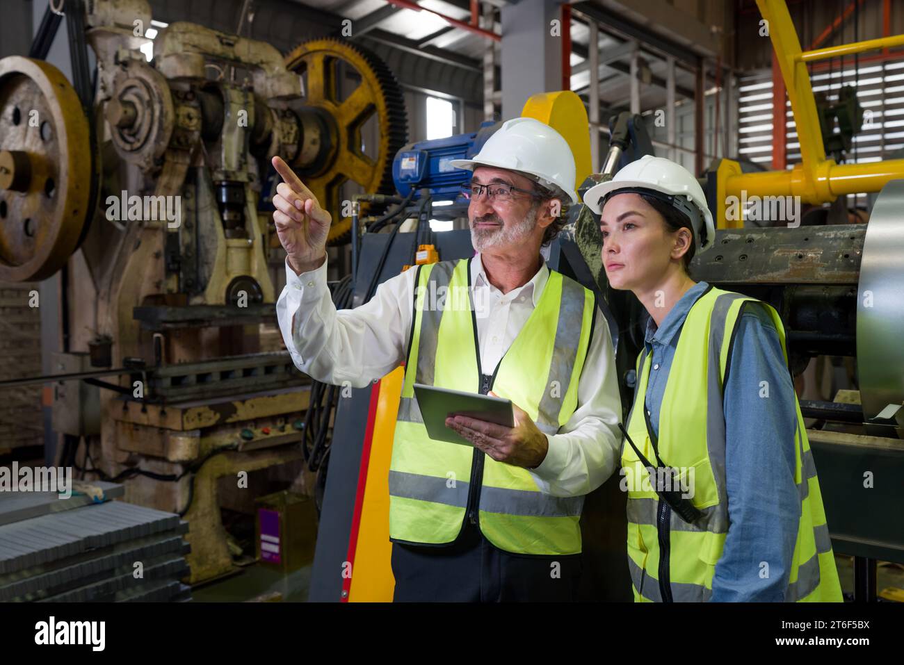 Senior engineer manager trains new employees within the metal sheet ...