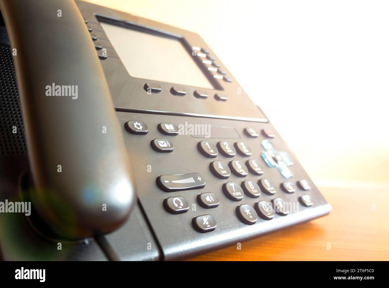 The black desktop push-button telephone. IP phone on desk in office ...