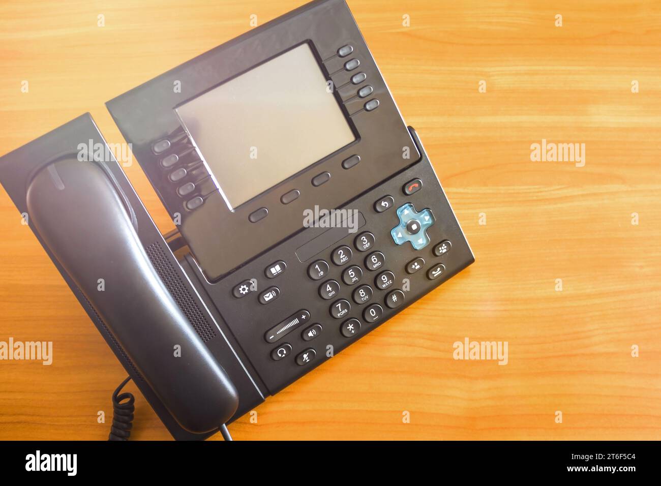 The black desktop push-button telephone. IP phone on desk in office ...