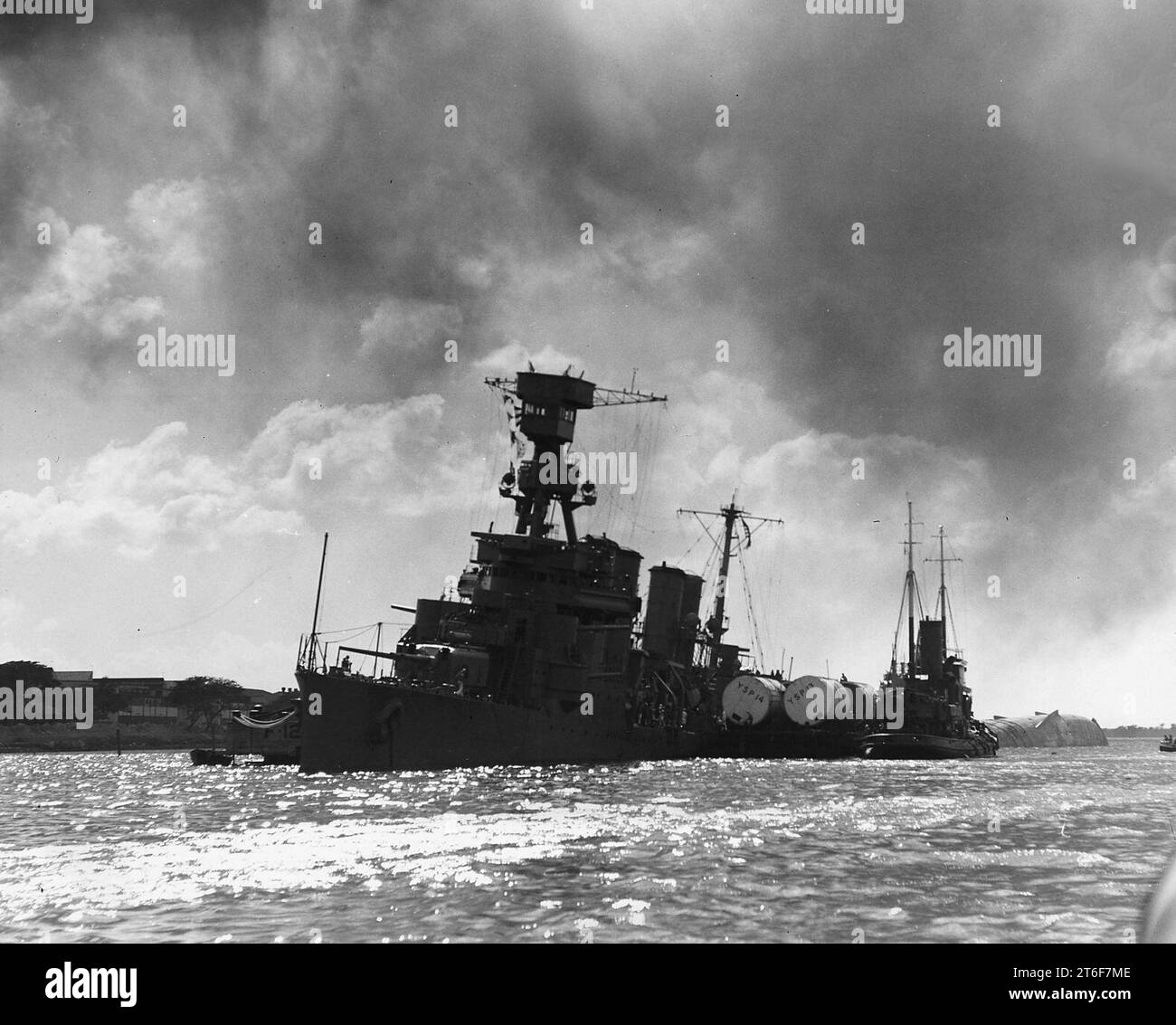 USS Raleigh (CL-7) being kept afloat by a barge lashed alongside, Pearl ...