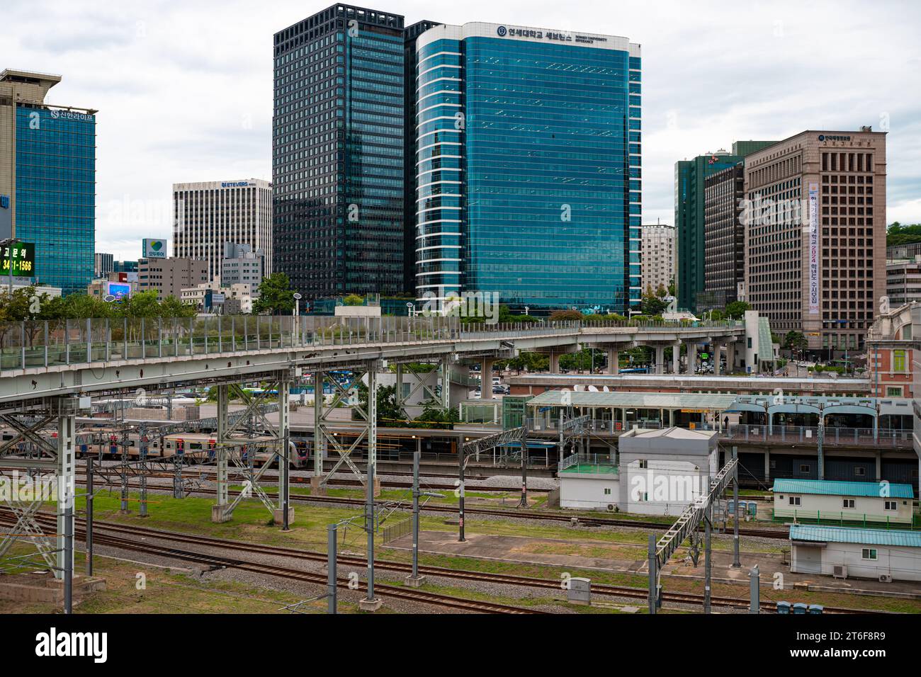 A modern train chugging along the tracks in front of a vibrant city ...