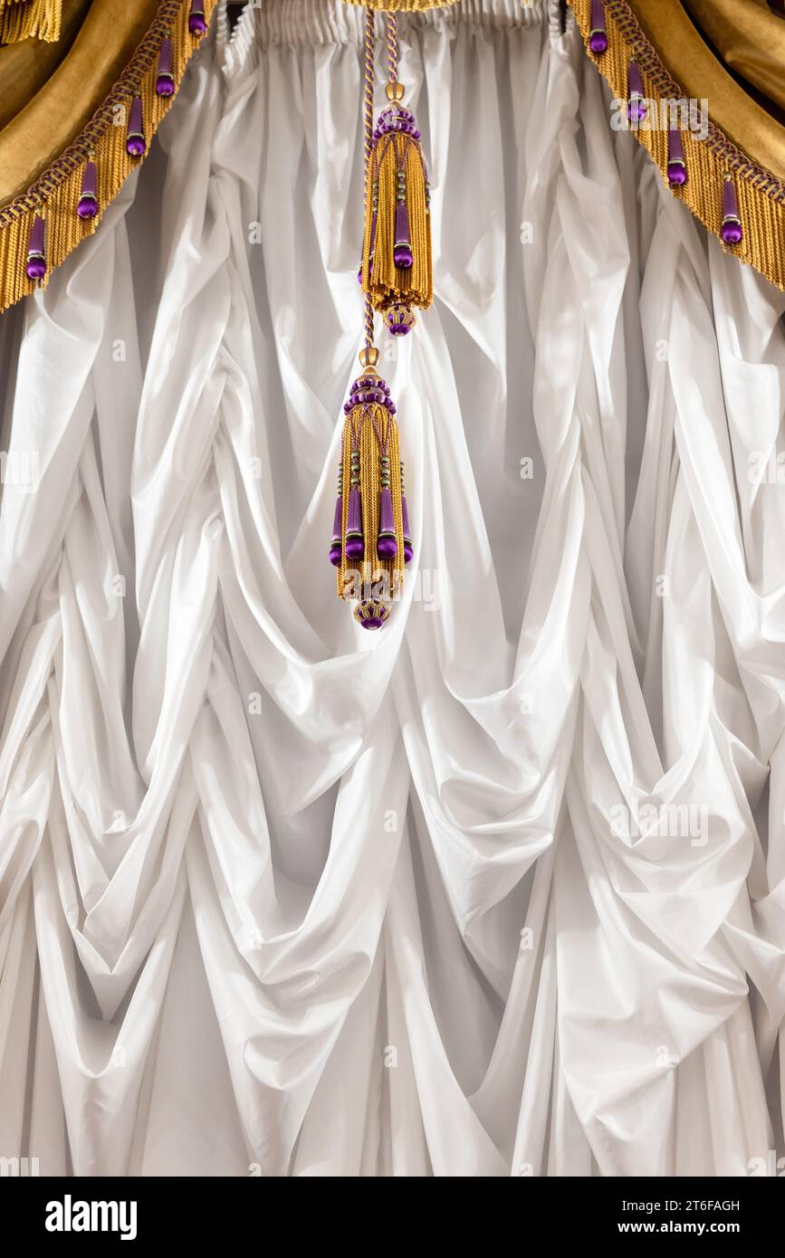 Luxury white curtains with golden fringe and tassel. Vertical ...