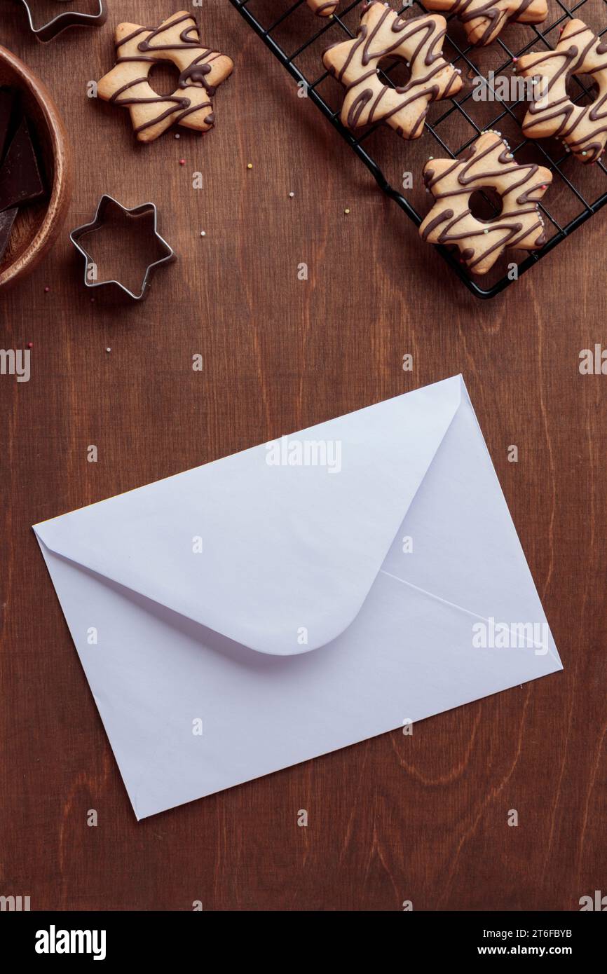 White letter envelope on the brown wooden background with fresh baked ...