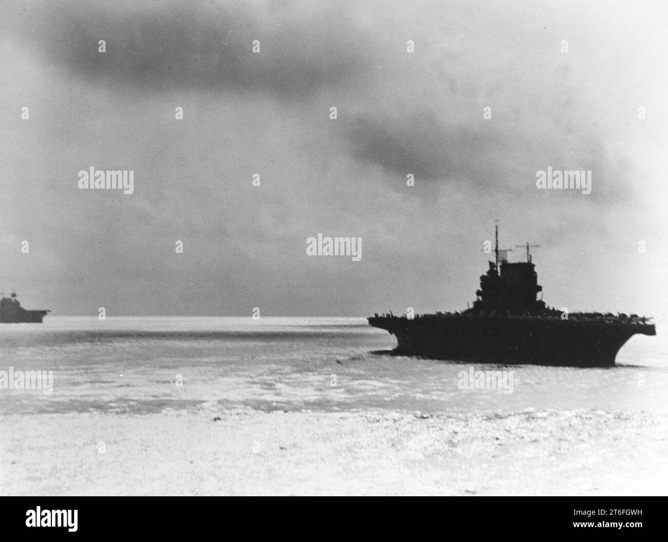 USS Saratoga (CV-3) operating near a rain squall in the Solomons ...