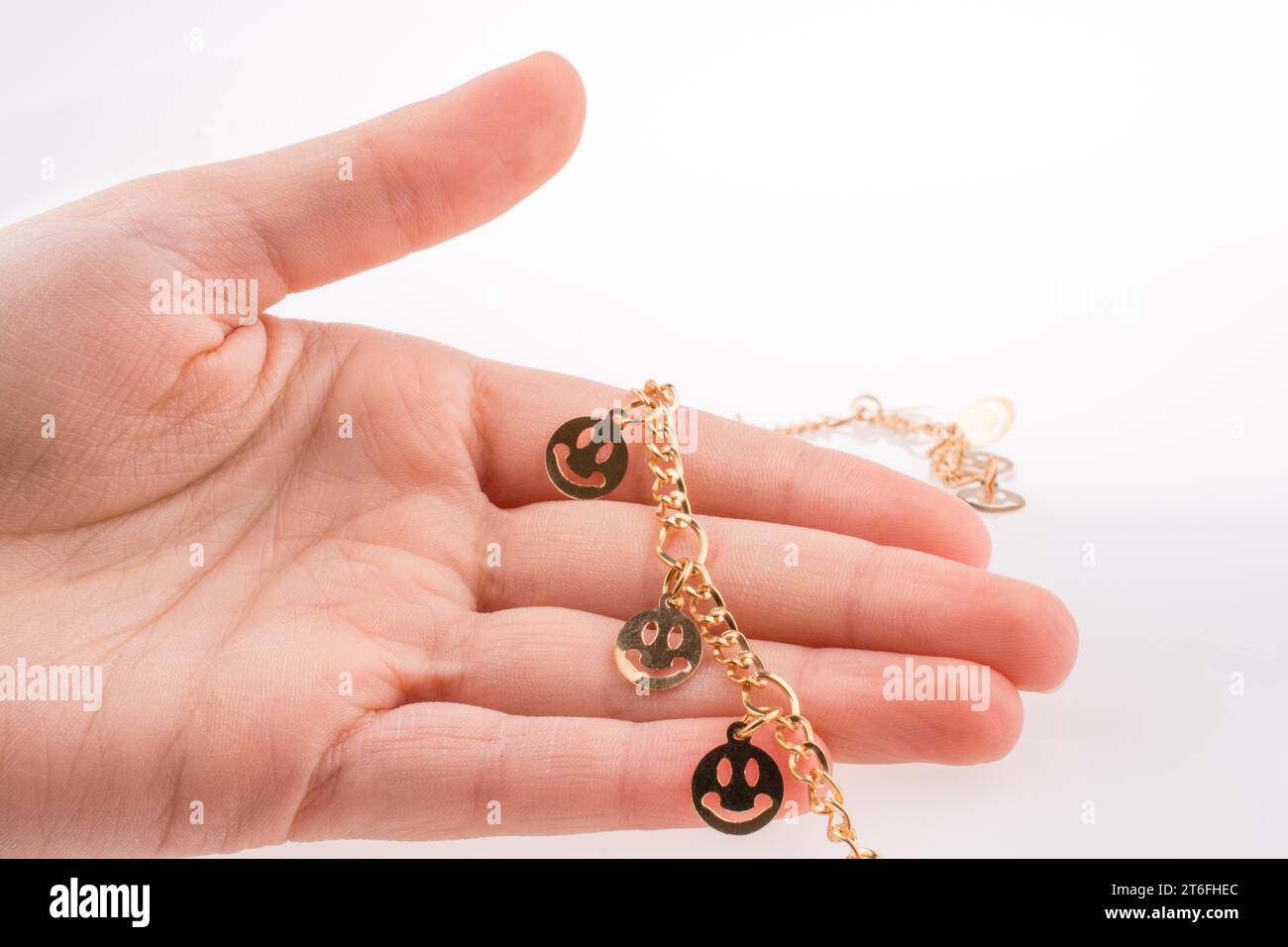 Golden color smileys arrayed on a chain in hand Stock Photo - Alamy