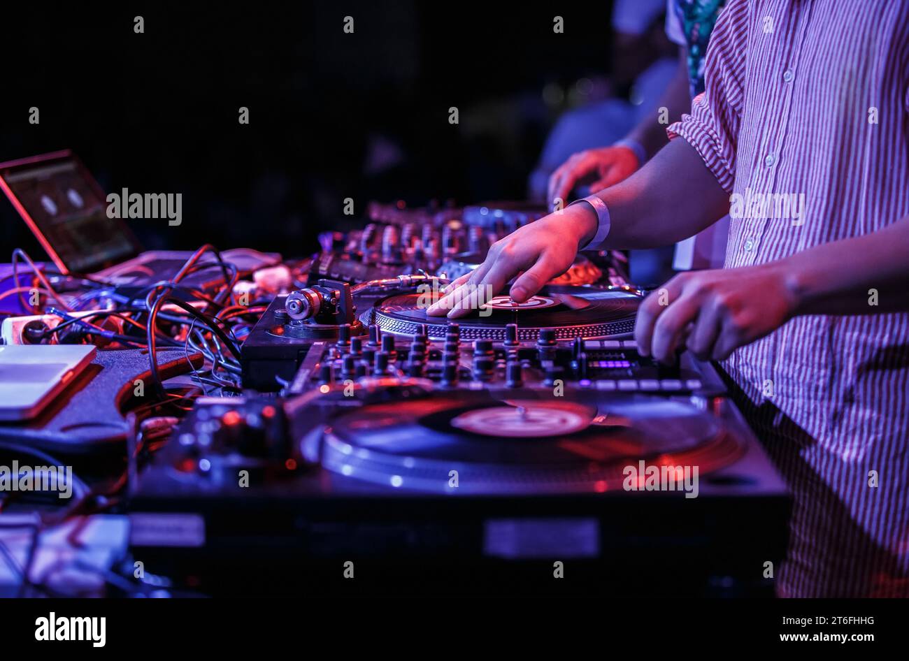 Hip hop DJ scratches vinyl records on turntables. Disk jockey mixing ...