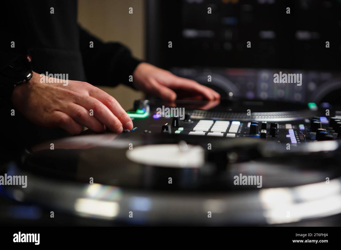 Disk jokey scratches a record on a turn table. Hip hop DJ playing music ...