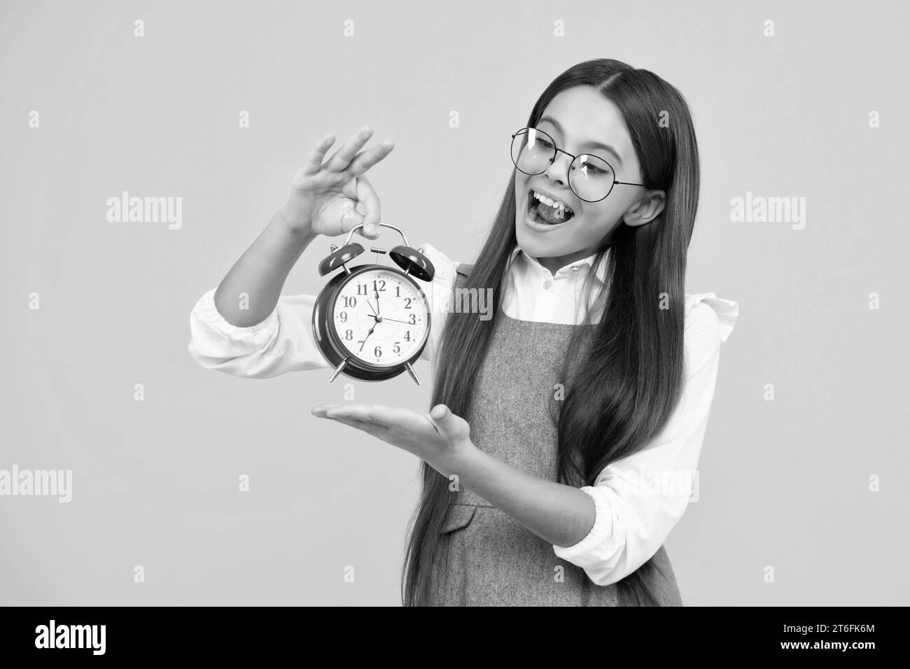 Teen girl 12, 13, 14 years old look at alarm clock. Time for shopping ...