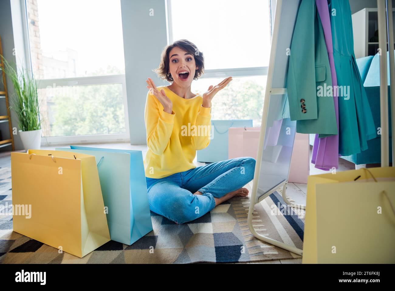 Photo of positive cheerful lady sitting floor with many shopping bags ...