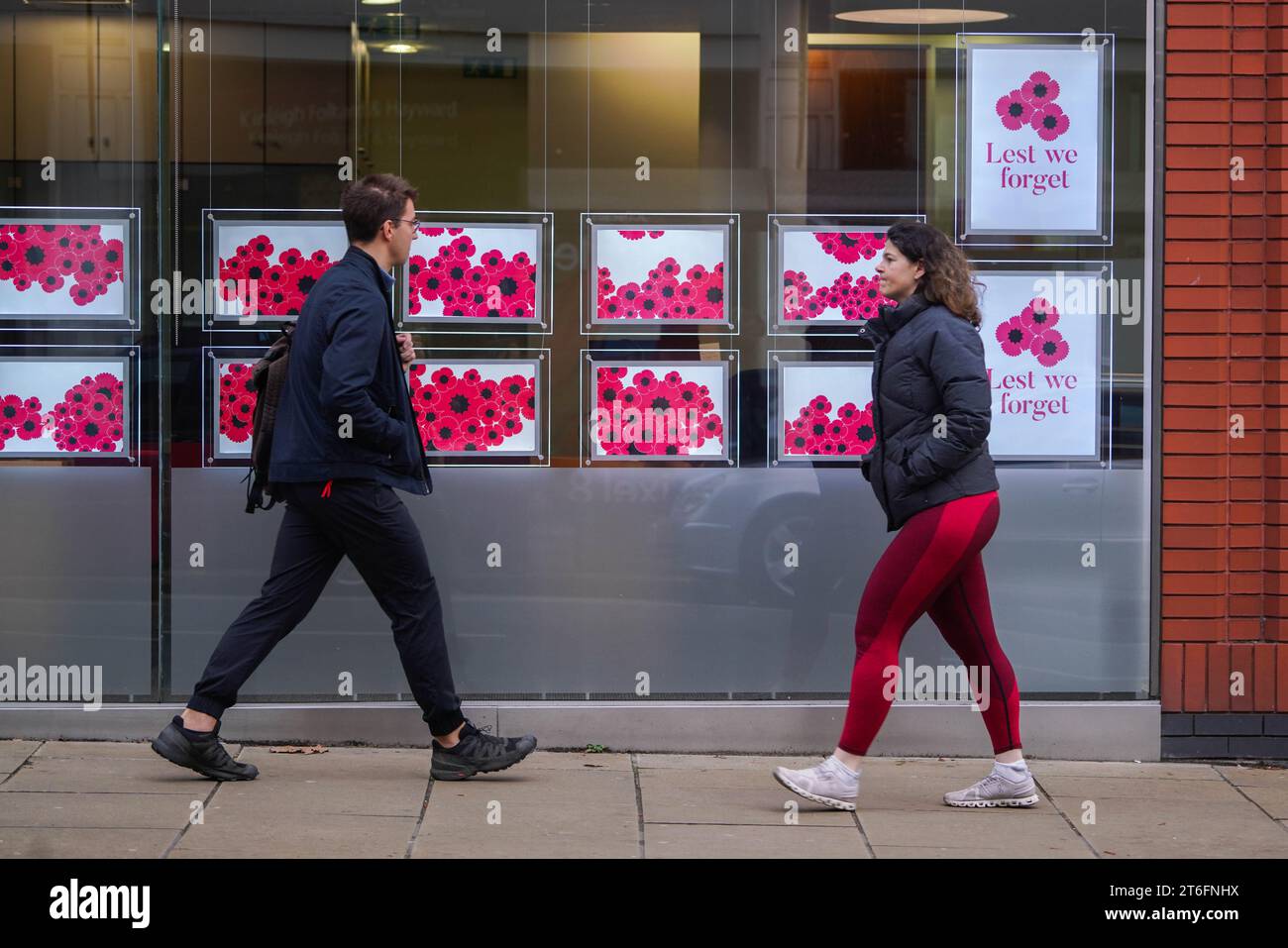 London, UK. 10 November 2023. Pedestrians walk past remembrance poppies ...