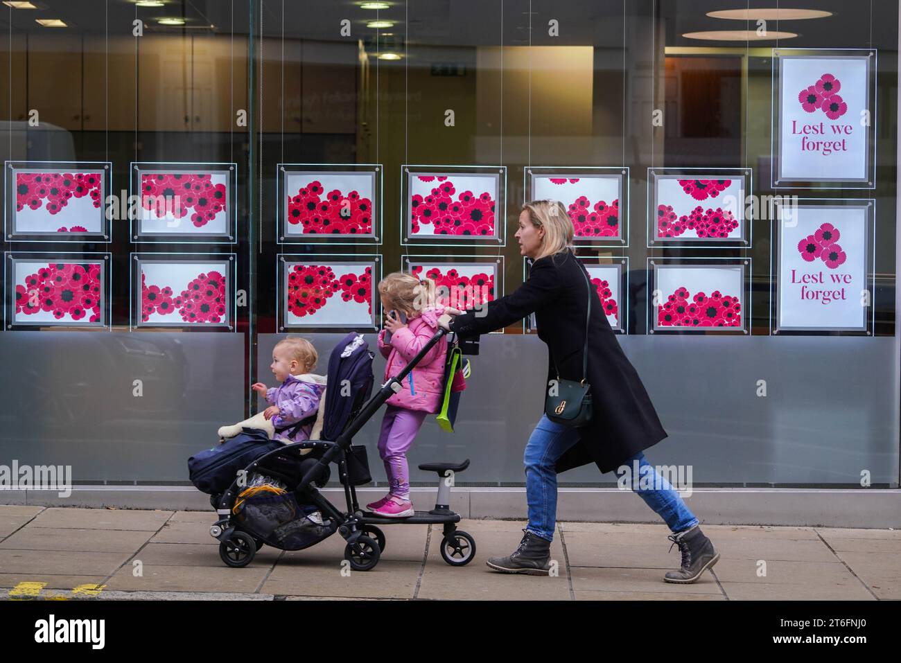 London, UK. 10 November 2023. Pedestrians walk past remembrance poppies ...