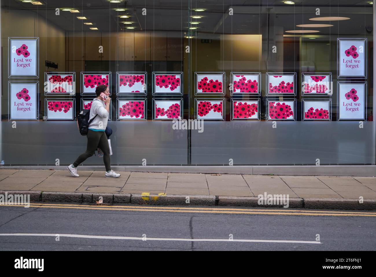 London, UK. 10 November 2023. Pedestrians walk past remembrance poppies ...