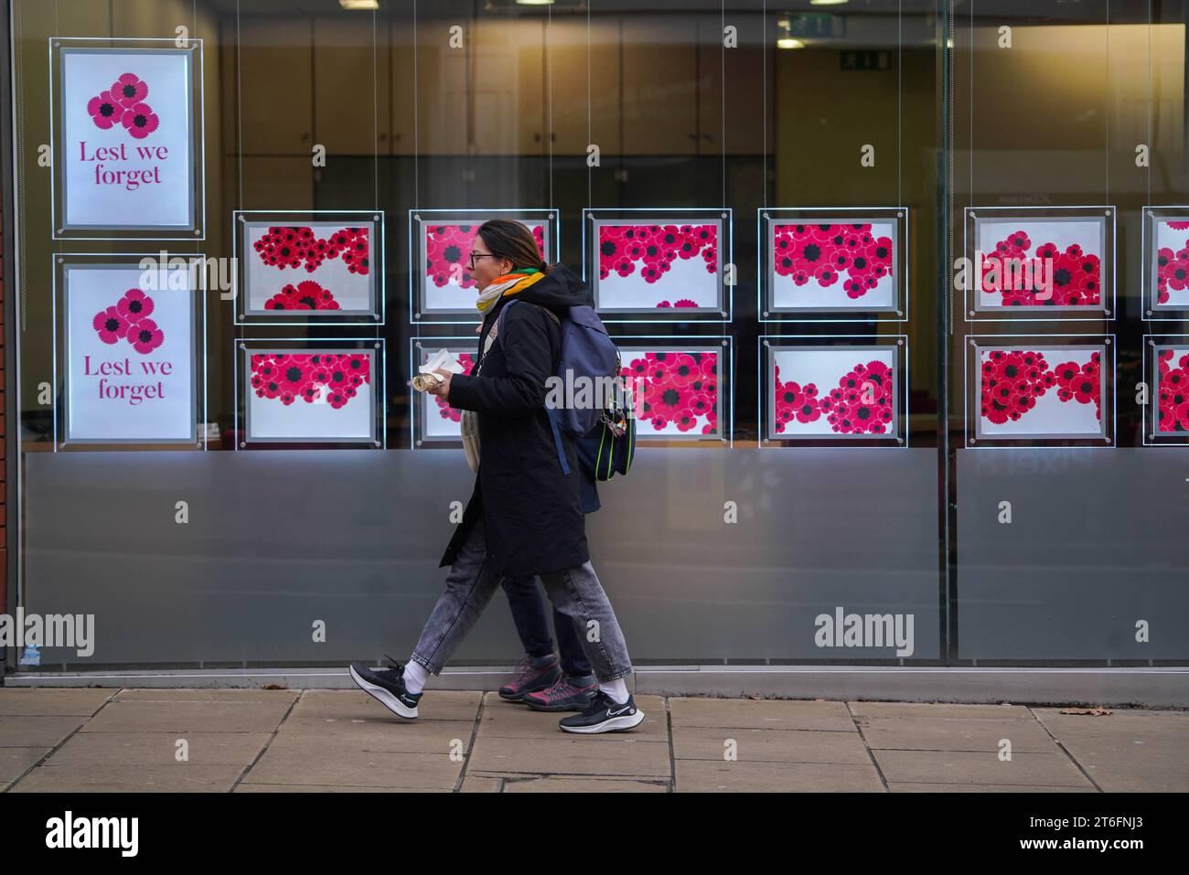 London, UK. 10 November 2023. Pedestrians walk past remembrance poppies ...