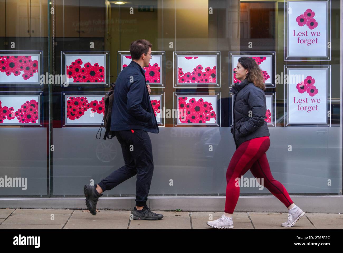 London, UK. 10 November 2023. Pedestrians walk past remembrance poppies ...