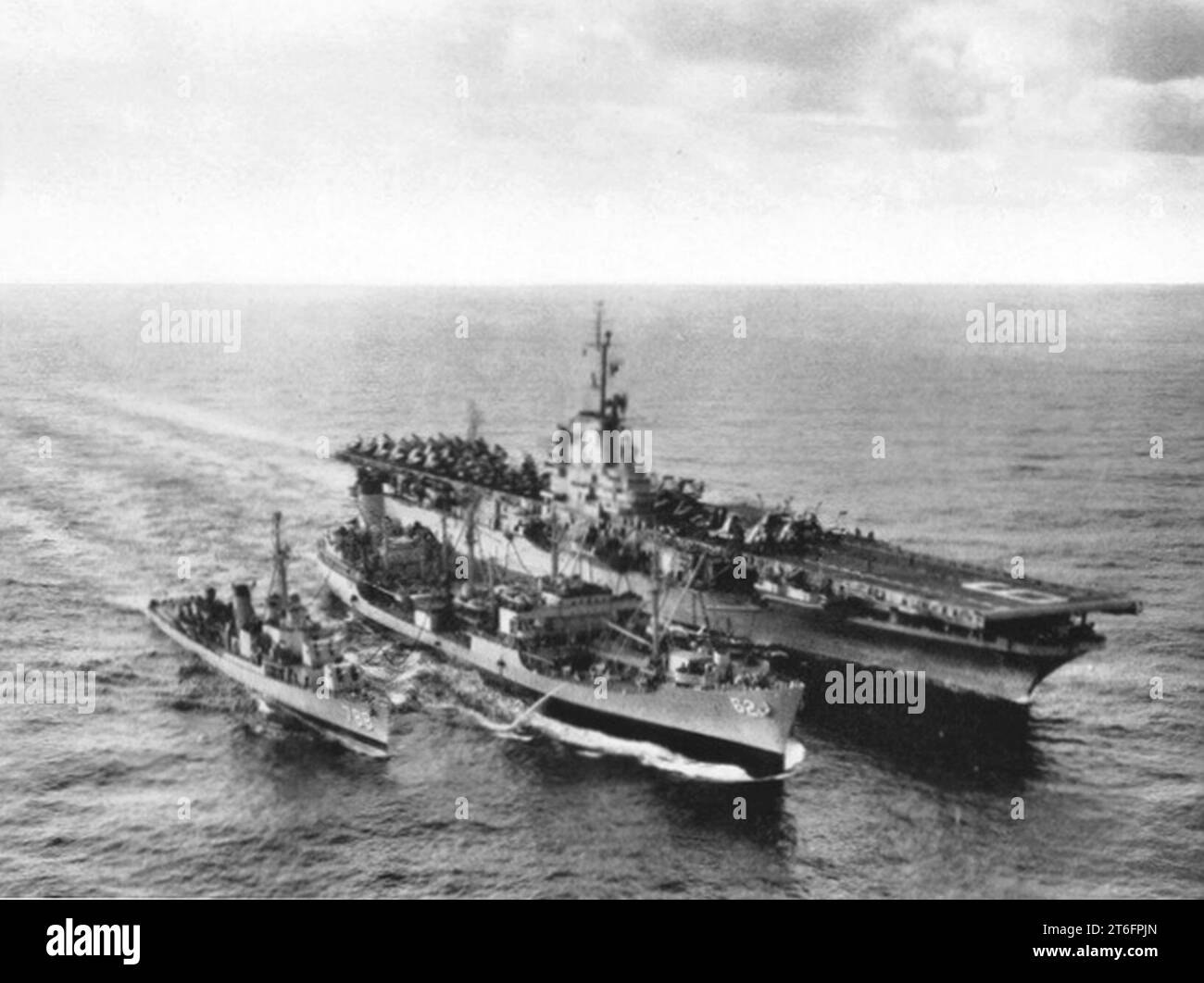 USS Taluga (AO-62) refueling USS Essex (CVA-9) and USS Hollister (DD ...